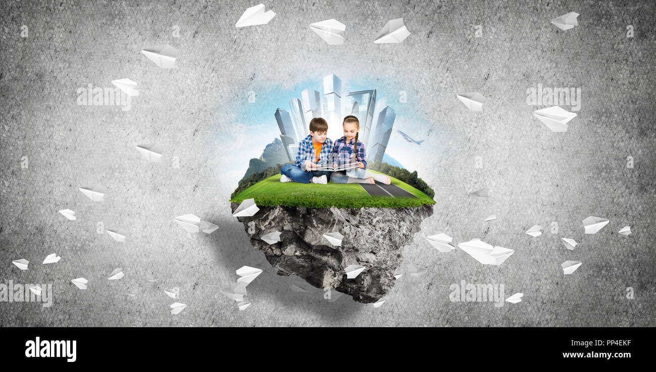 Two kids of school age with book exploring this great world Stock Photo ...
