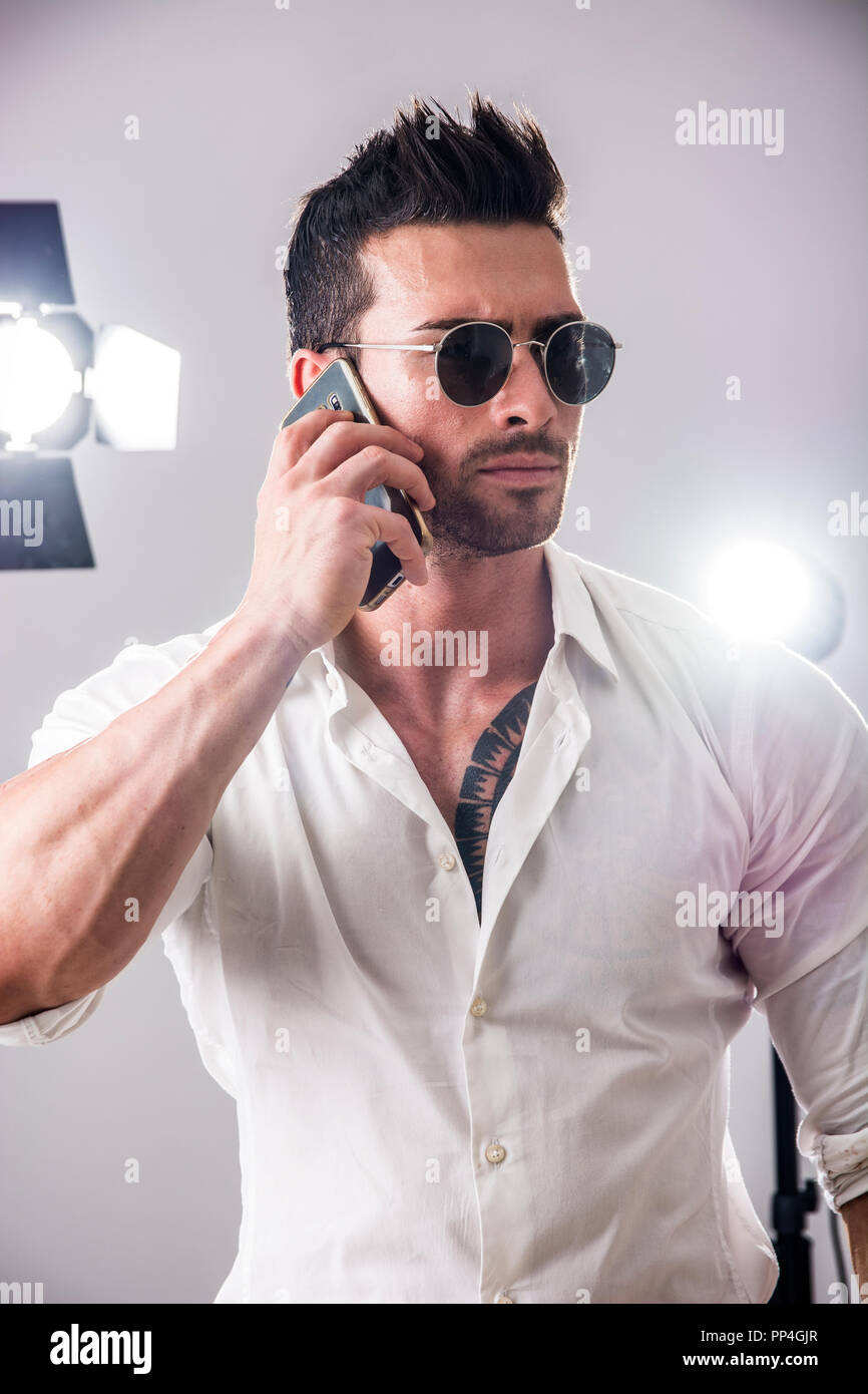Attractive VIP man in studio with spotlights behind him, talking on ...