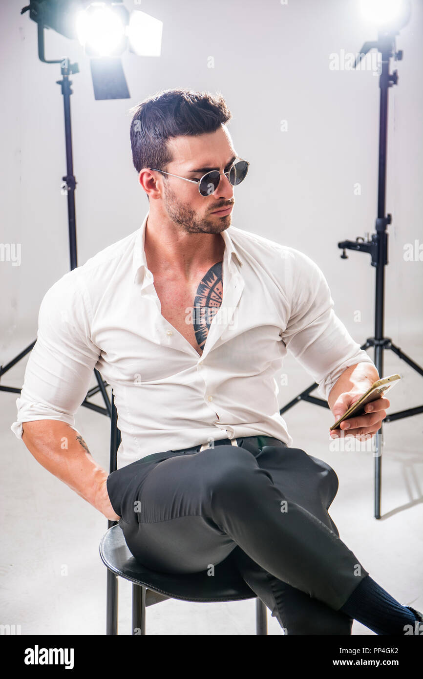 Attractive VIP man in studio with spotlights behind him, being ...