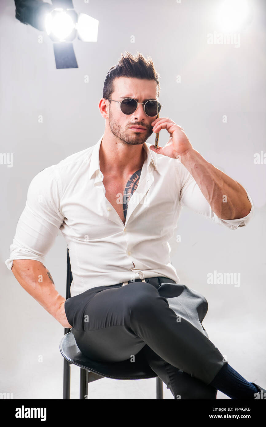 Attractive VIP man in studio with spotlights behind him, talking on ...