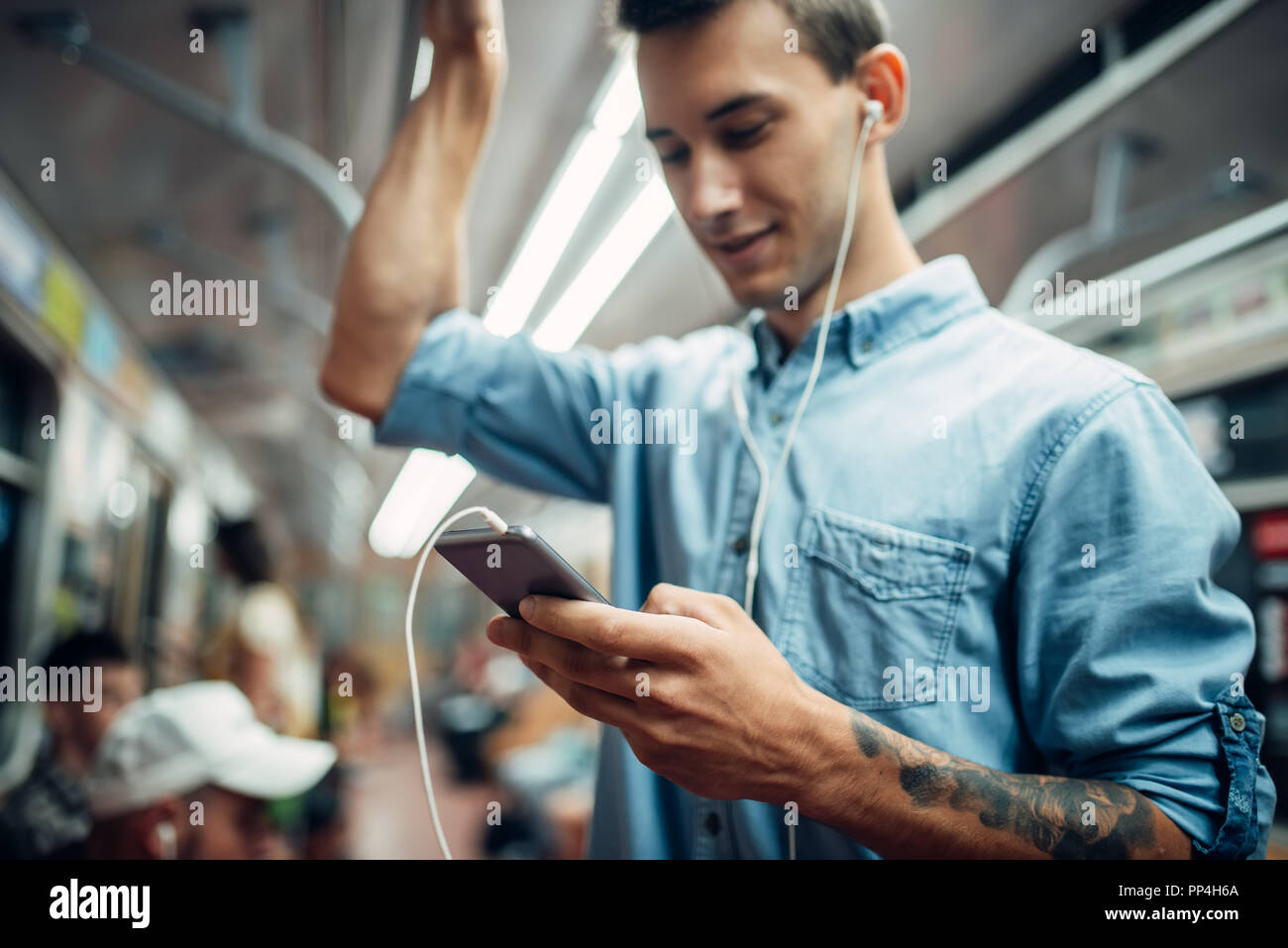 Young man using phones in subway, addiction problem, social addicted ...