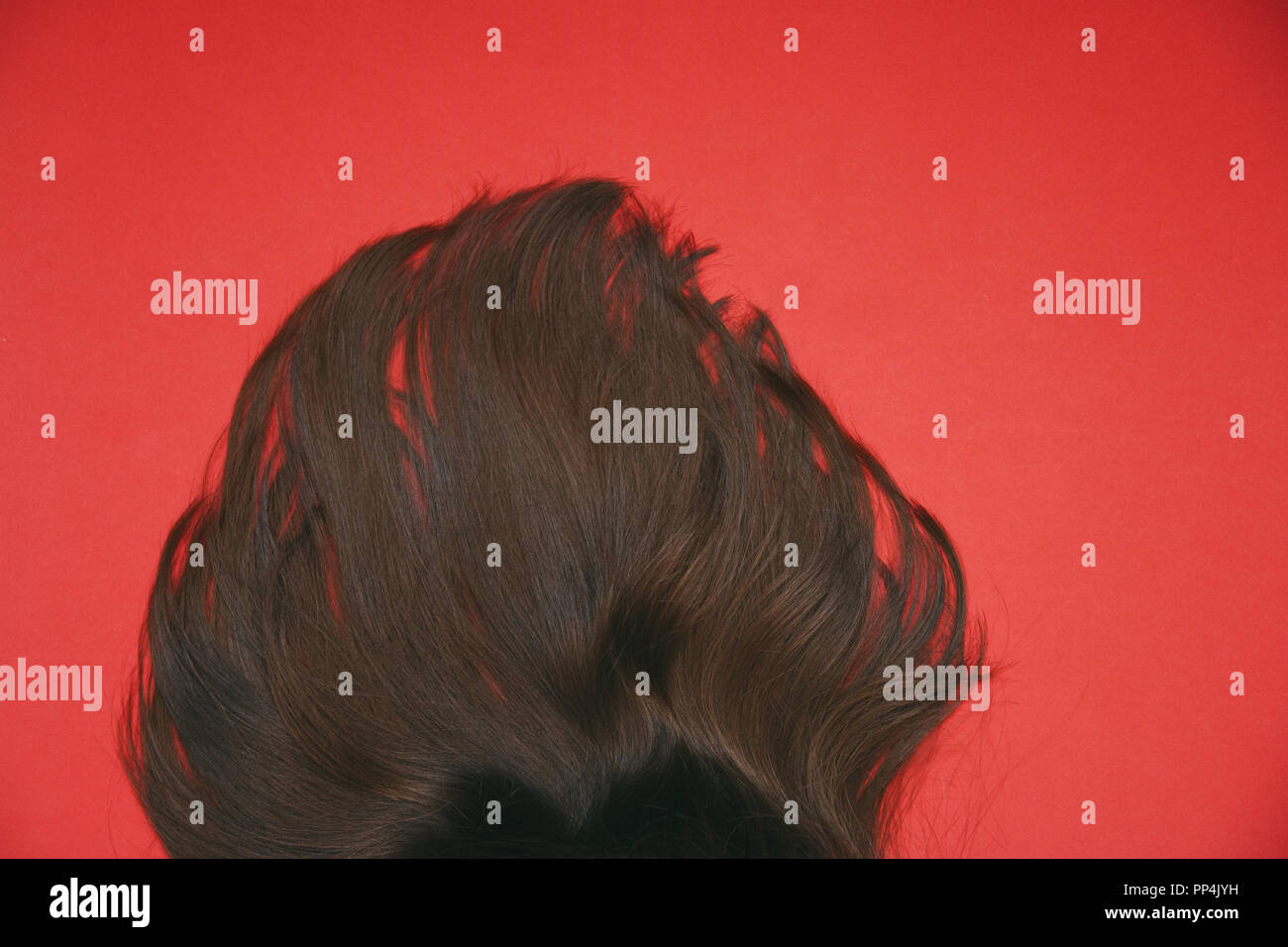 neatly packed flowing hair on a red background Stock Photo - Alamy