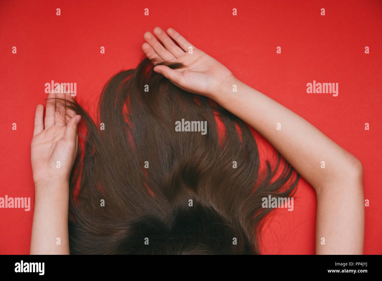neatly packed flowing hair and hands on a red background Stock Photo ...