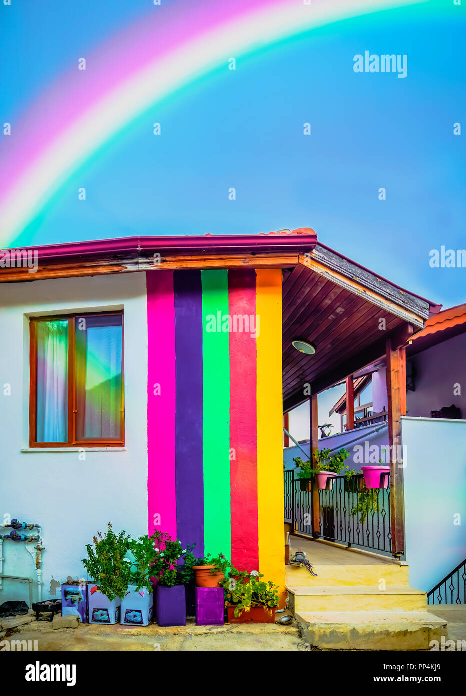 House's facade is decorated with rainbow color under rainbow in a rainy ...