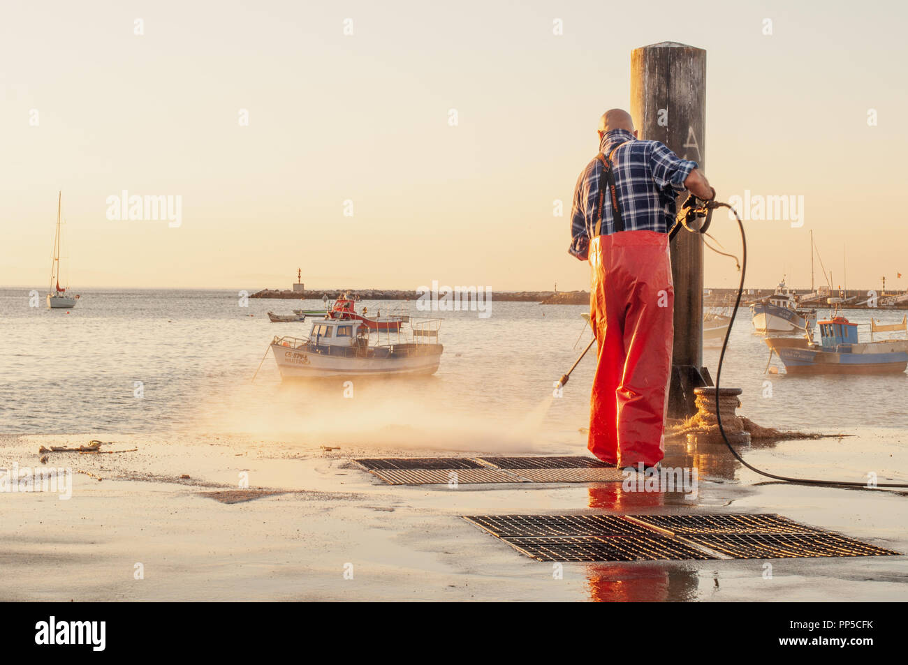 Man water jetting pier at dawn Stock Photo - Alamy