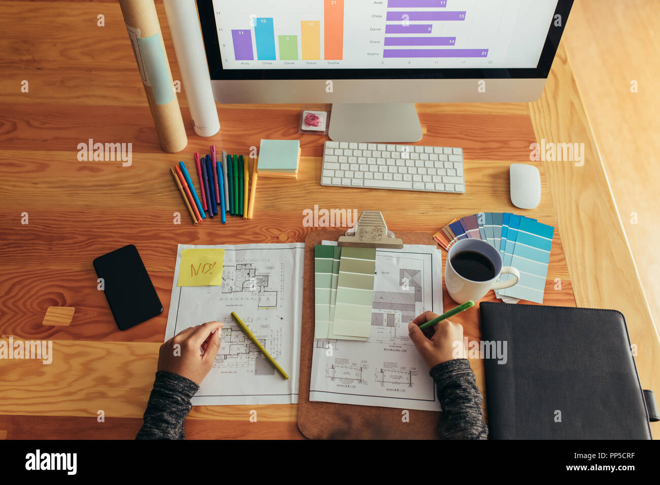 Top view of woman architect working over new blueprints at her desk ...