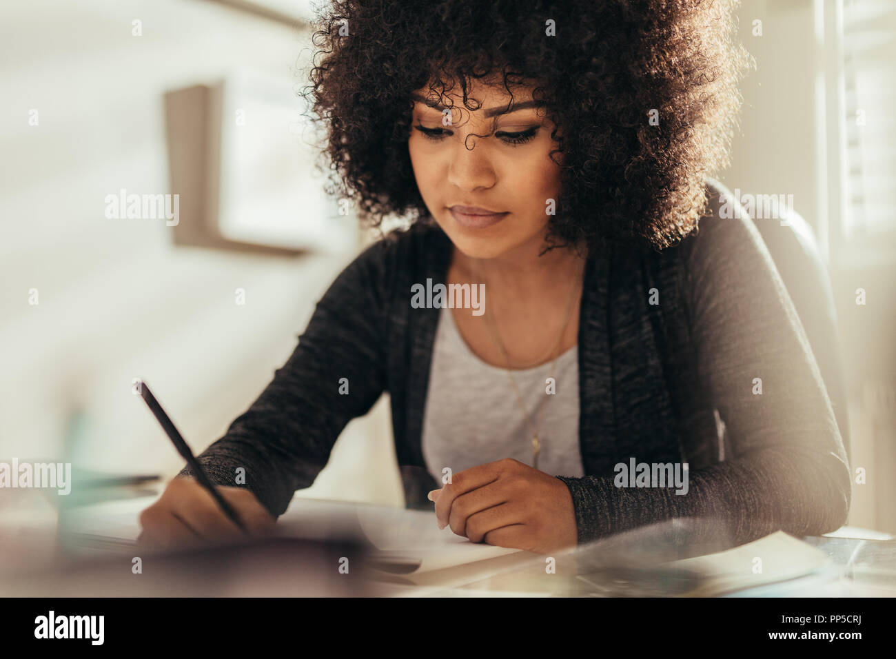 Portrait of female architect working at her desk. Busy female designer ...