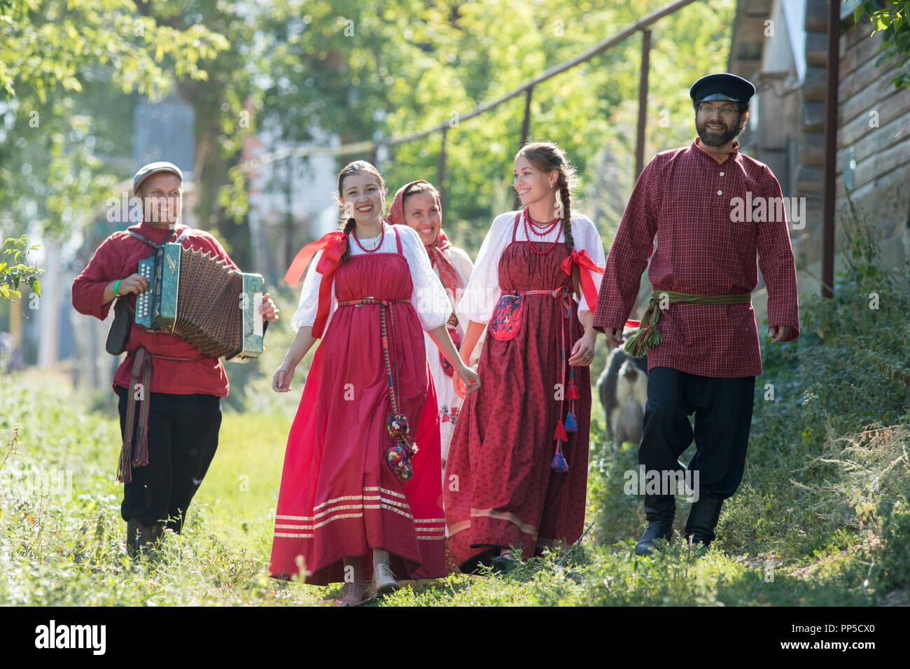 A group of young people in Russian national costumes walking around the ...