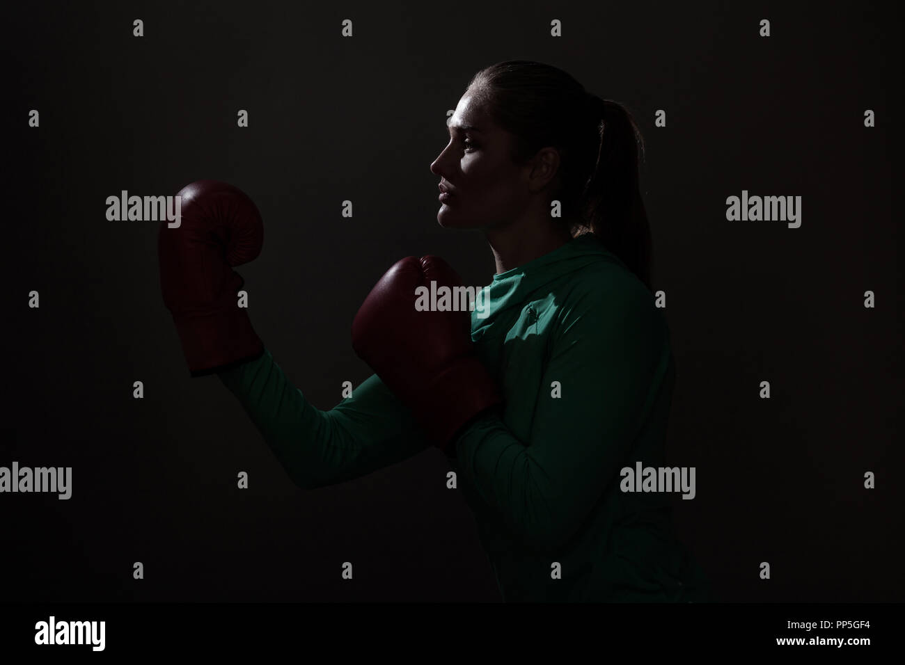 silhouette profile side view portrait of young boxer woman in green ...