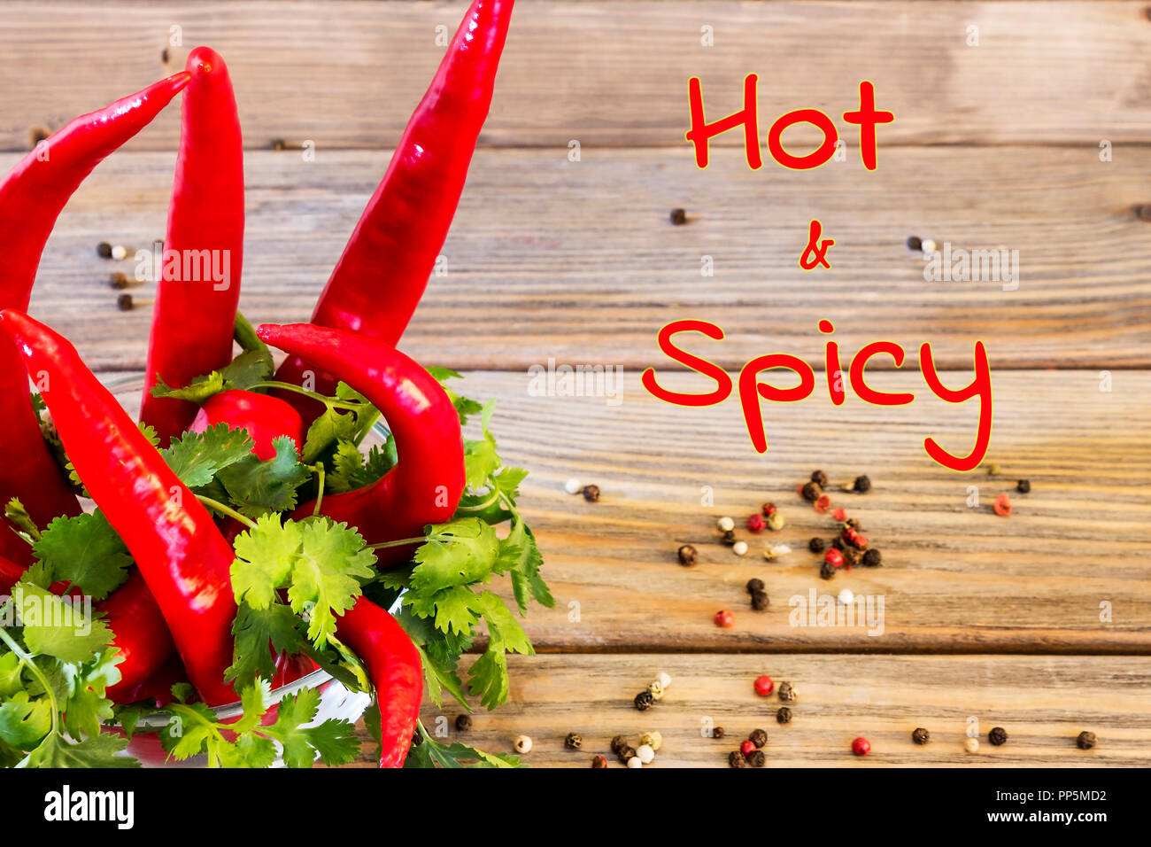 Red hot chili pepper and greenery on wooden background. Spicy and fresh ...