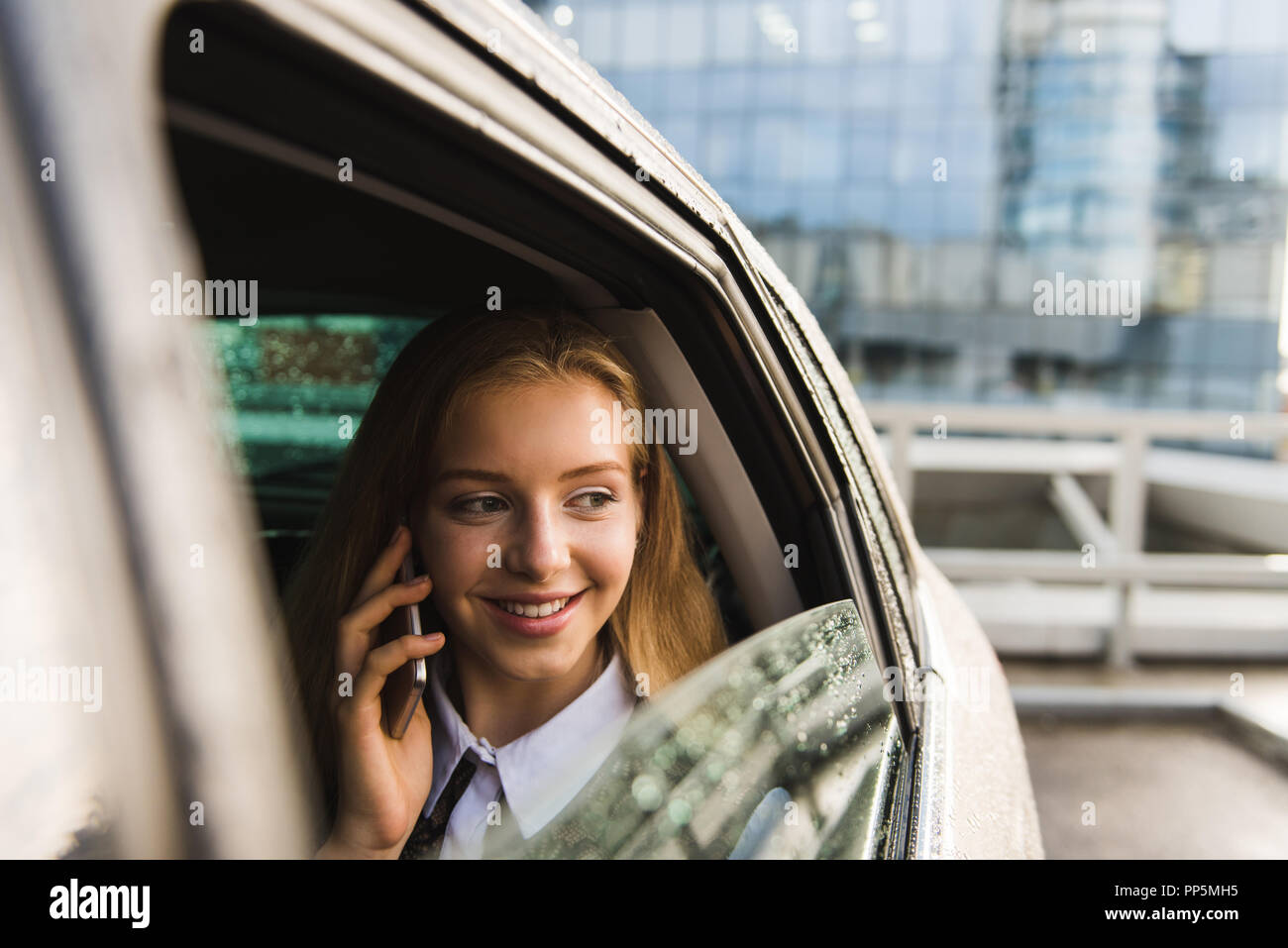 Girl with mobile phone smile in car Stock Photo - Alamy