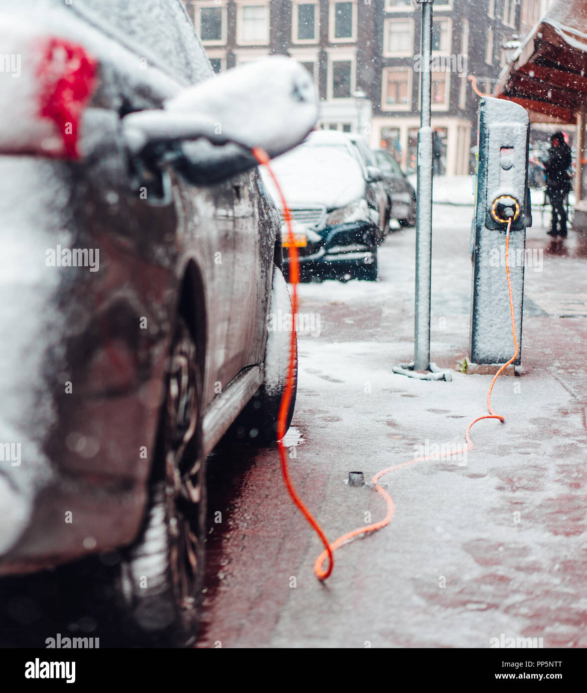 Electric car plug charging in the winter Stock Photo - Alamy