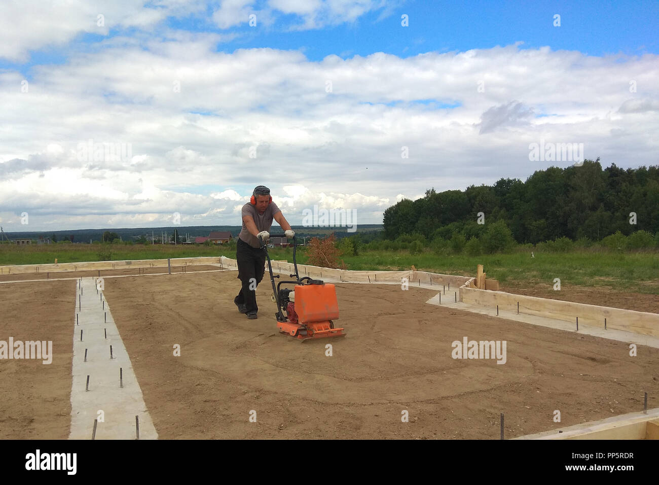 Soil compaction by a worker with a vibroplate Stock Photo - Alamy
