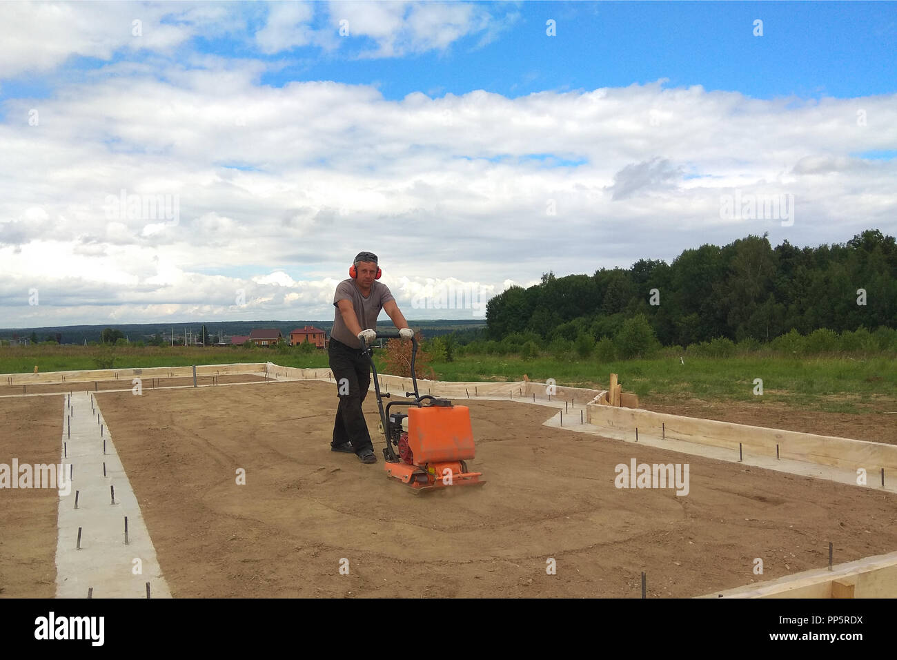 Soil compaction by a worker with a vibroplate Stock Photo - Alamy