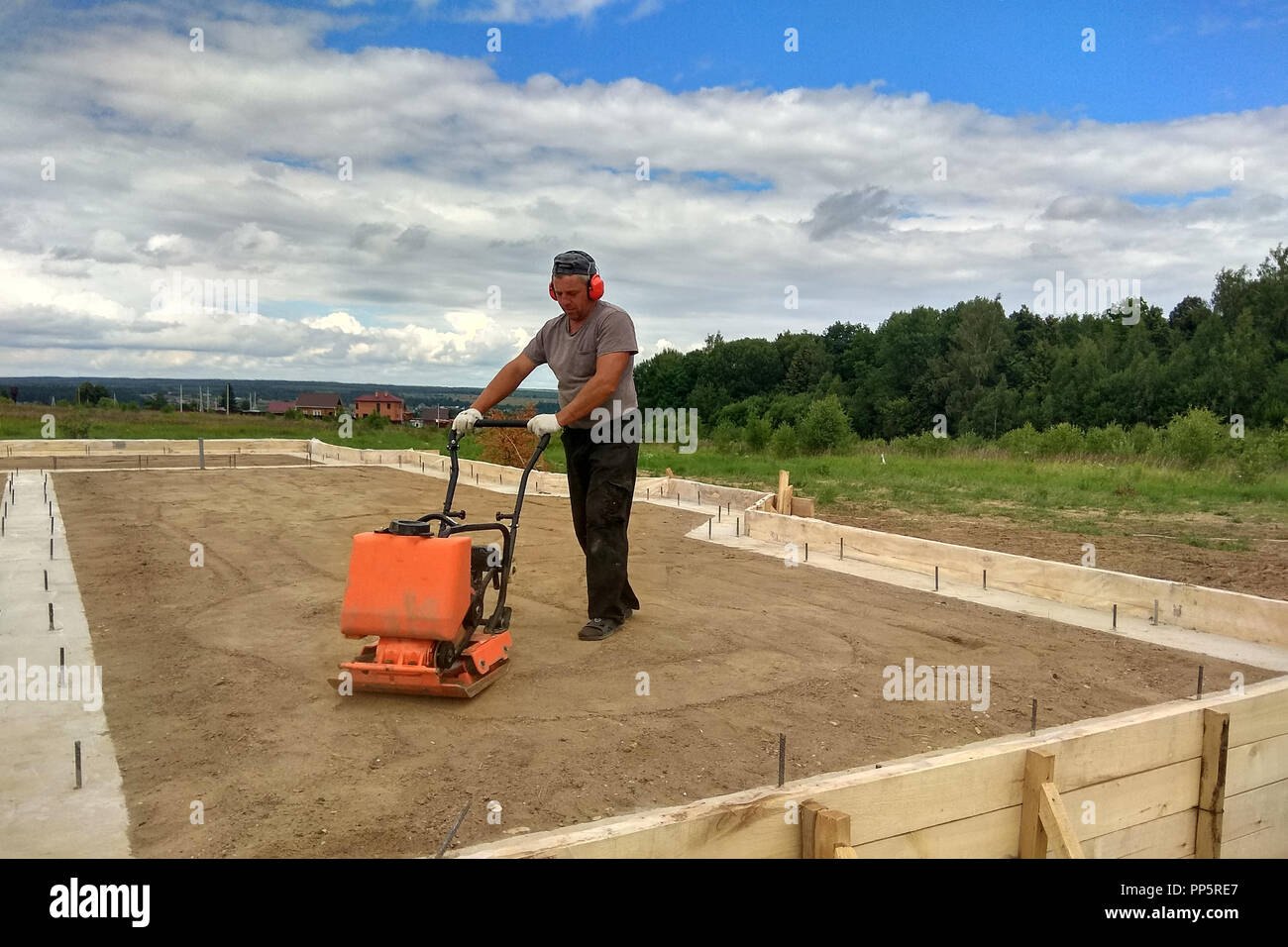 Soil compaction by a worker with a vibroplate Stock Photo - Alamy