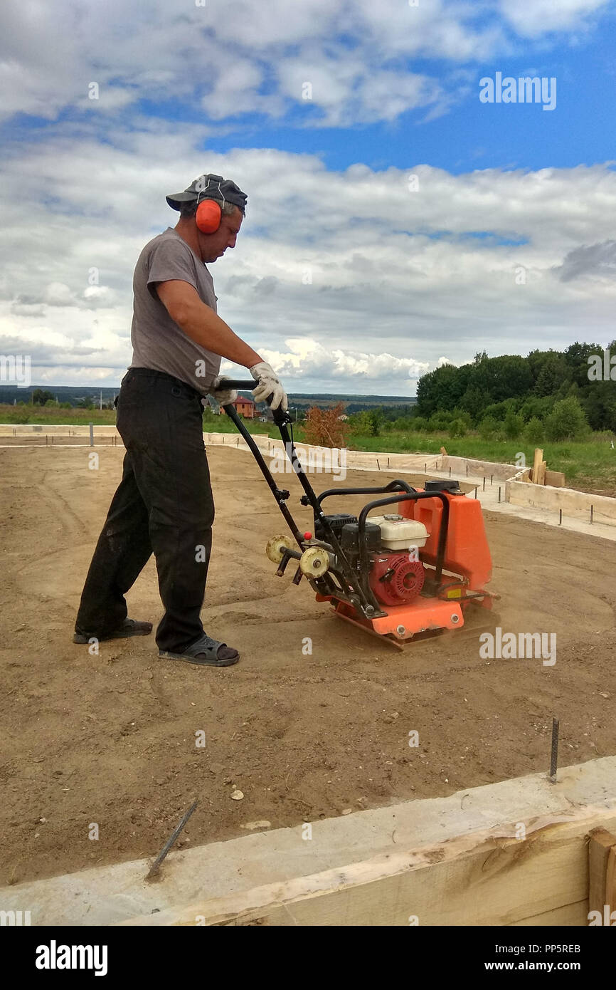 Soil compaction by a worker with a vibroplate Stock Photo - Alamy