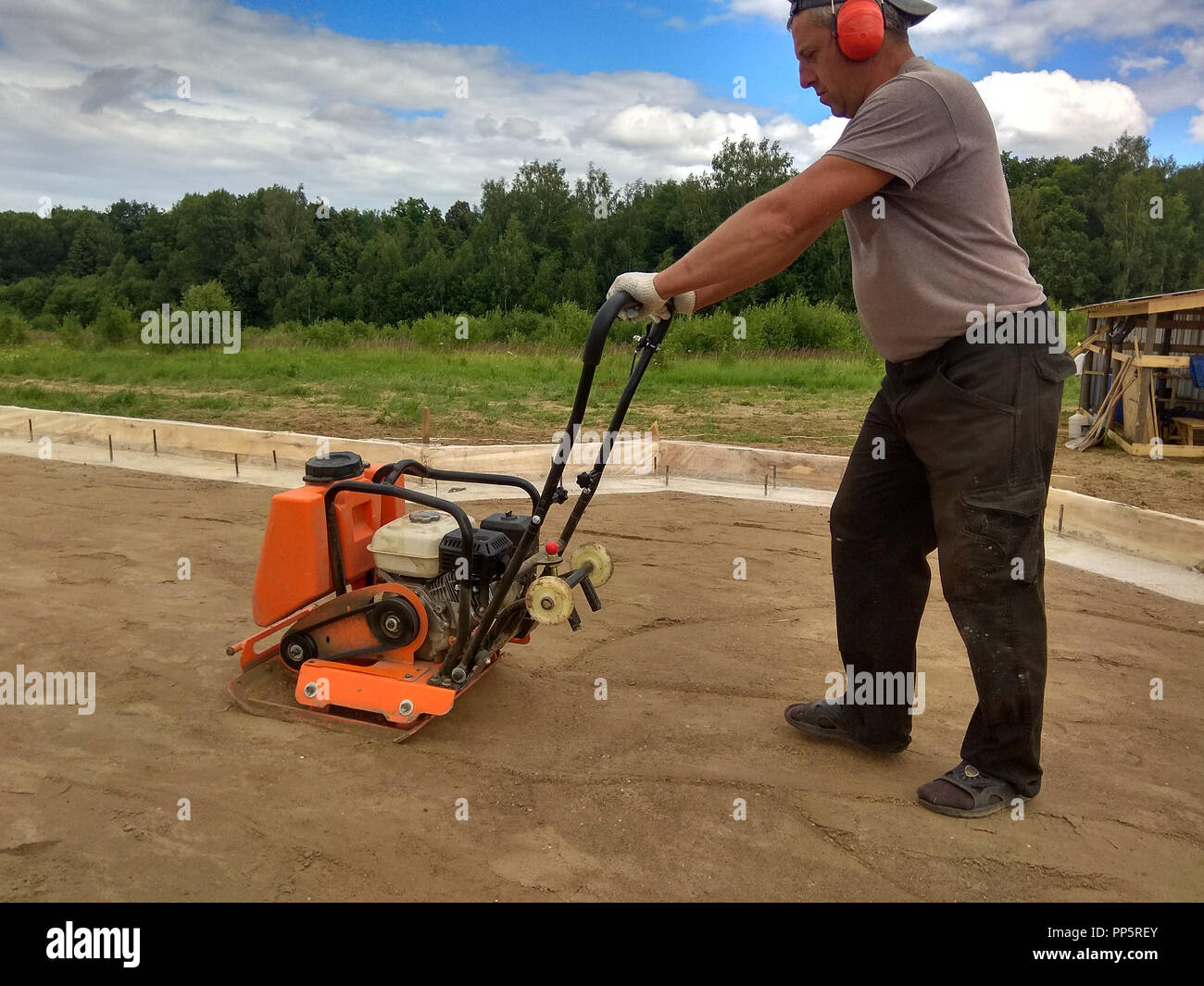 Soil compaction by a worker with a vibroplate Stock Photo - Alamy