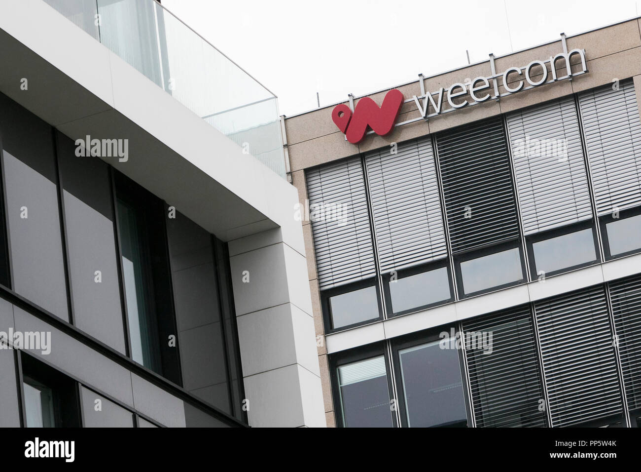 A logo sign outside of a facility occupied by Wee.Com AG in Munich ...
