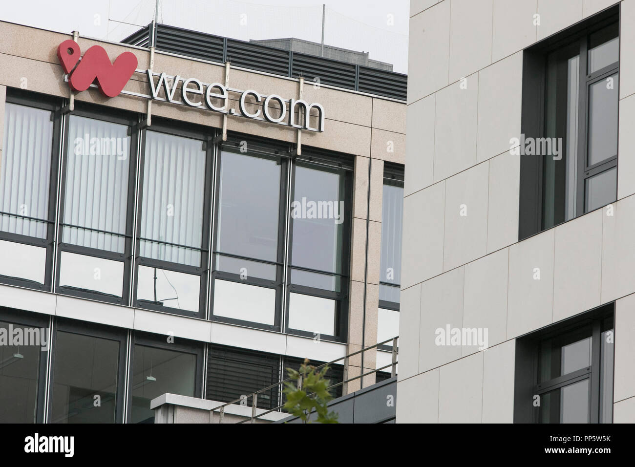 A logo sign outside of a facility occupied by Wee.Com AG in Munich ...