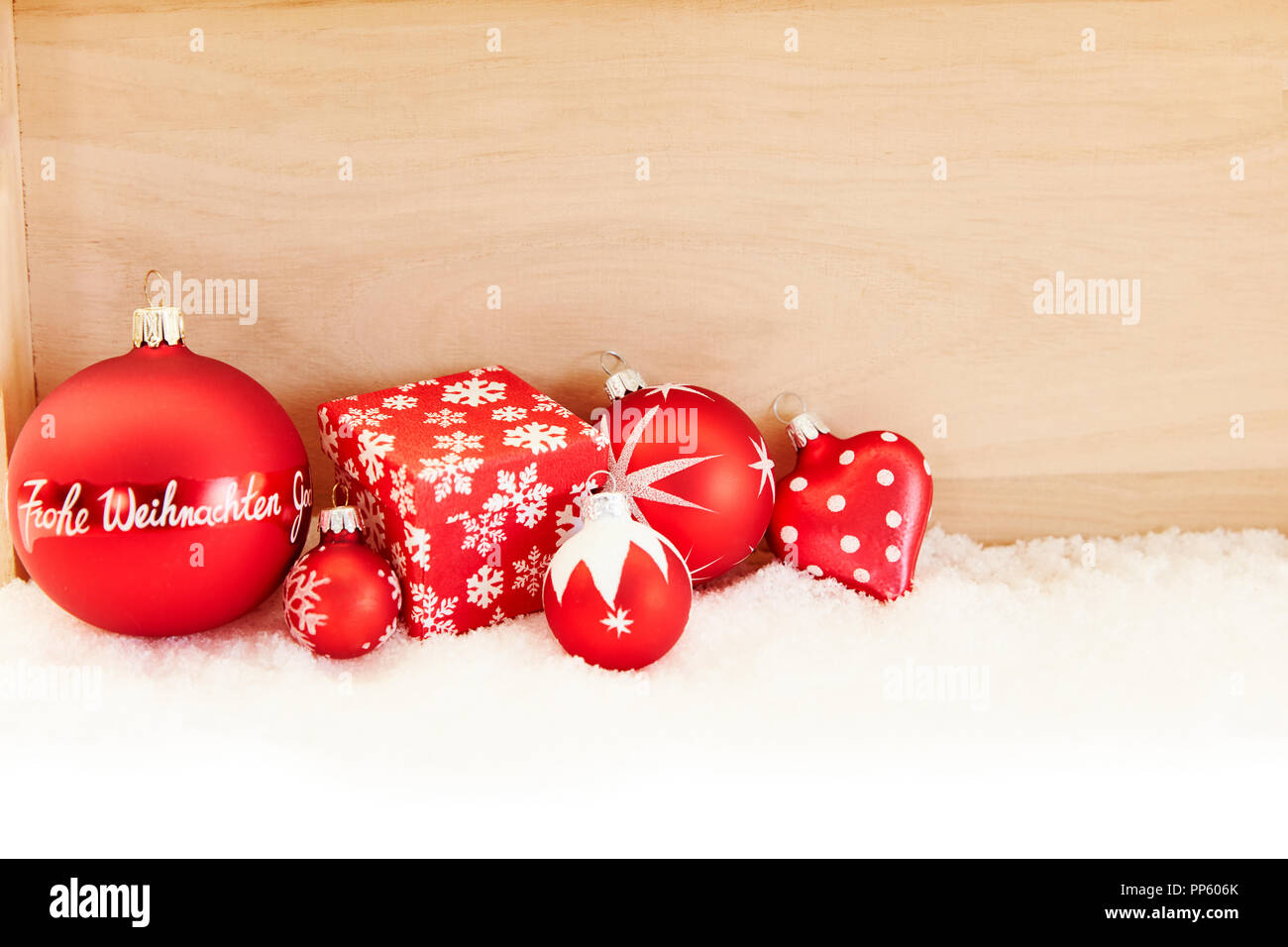 German text "Frohe Weihnachten" (Merry Christmas) on bauble in red with ...