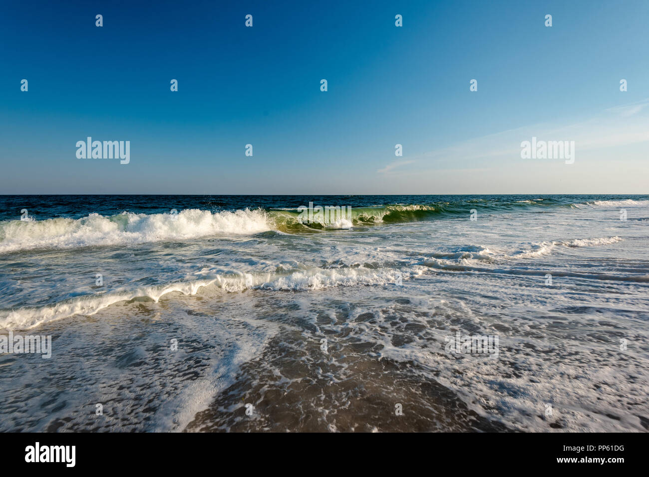 Ocean waves on a sunny sandy beach Stock Photo - Alamy