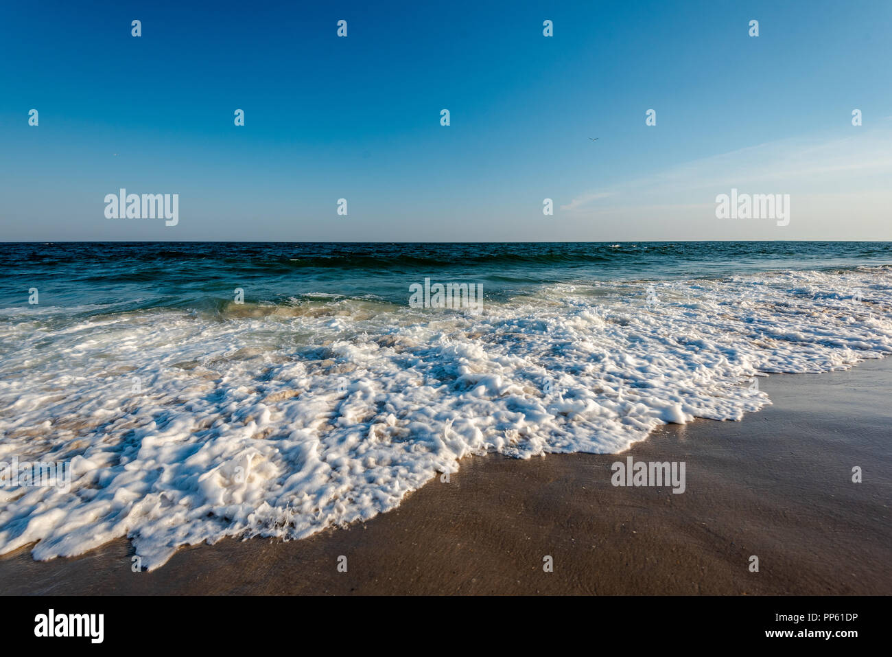 Ocean waves on a sunny sandy beach Stock Photo - Alamy