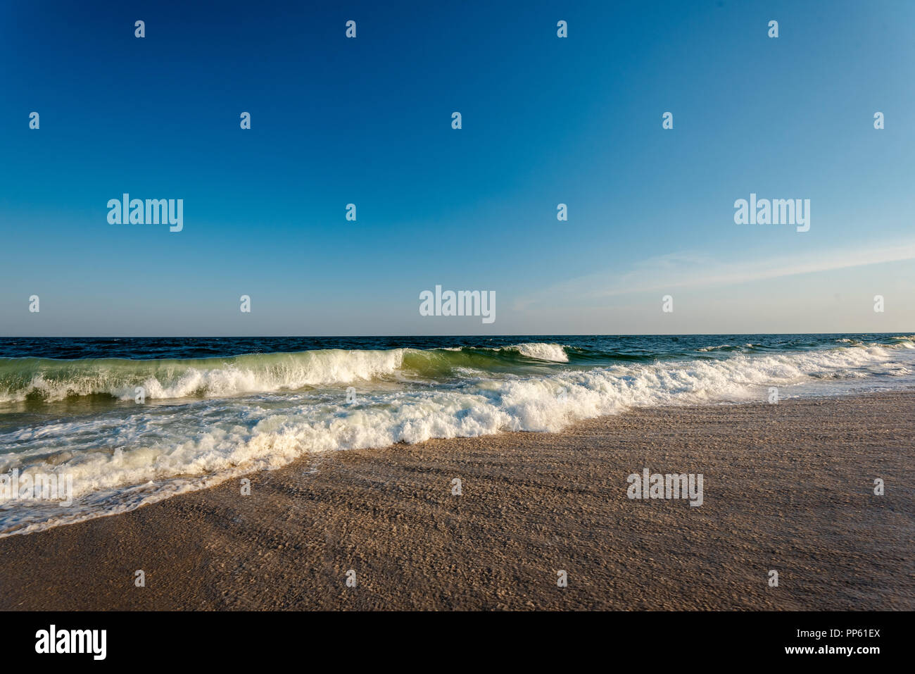 Ocean waves on a sunny sandy beach Stock Photo - Alamy