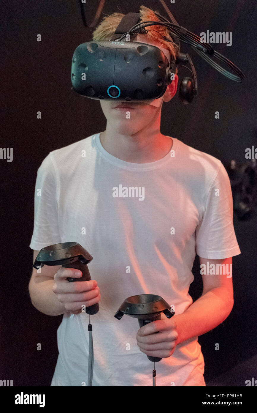 Visitor with virtual reality glasses and controllers at the World of ...