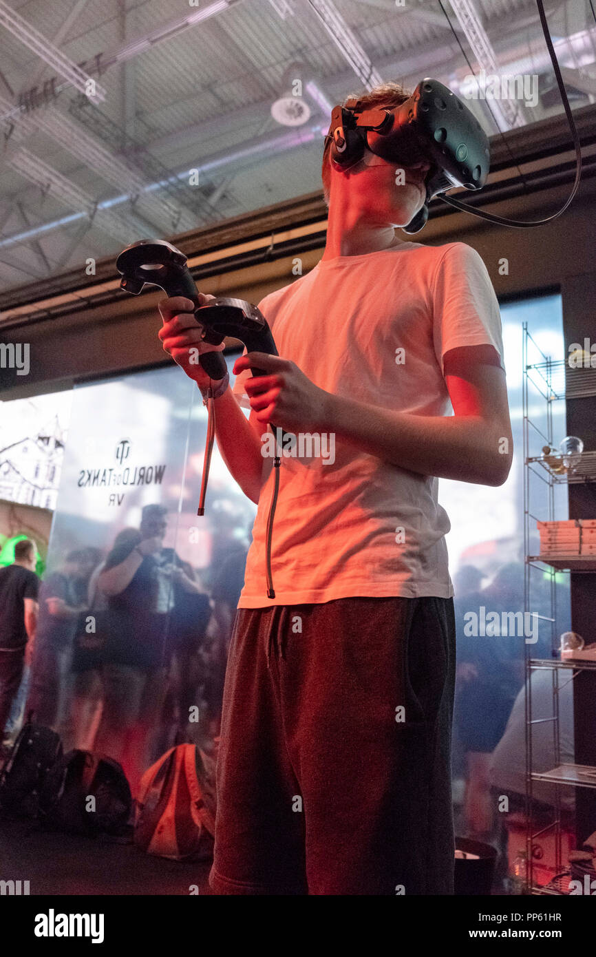 Visitor with virtual reality glasses and controllers at the World of ...