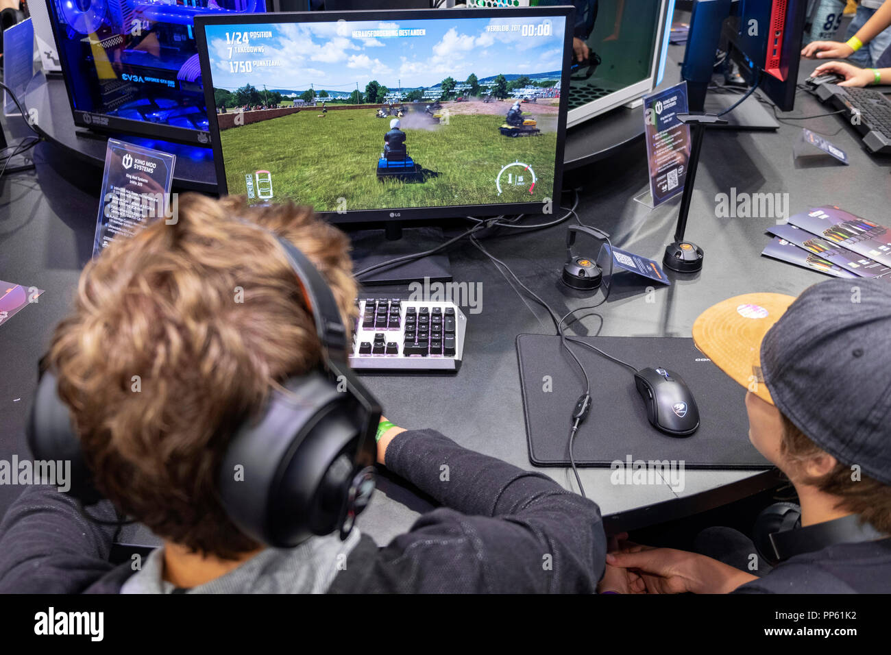 Teenagers play a computer car racing game at the world's largest fair ...