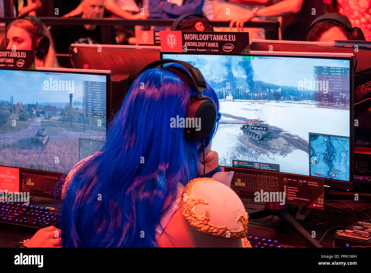 Visitor in cosplay costume sitting in front of a military computer game ...