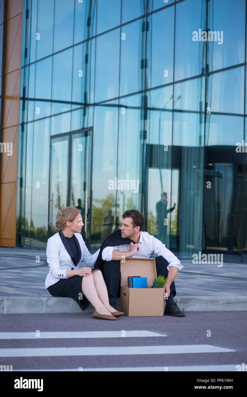 Fired business man sitting frustrated and upset on the street near ...