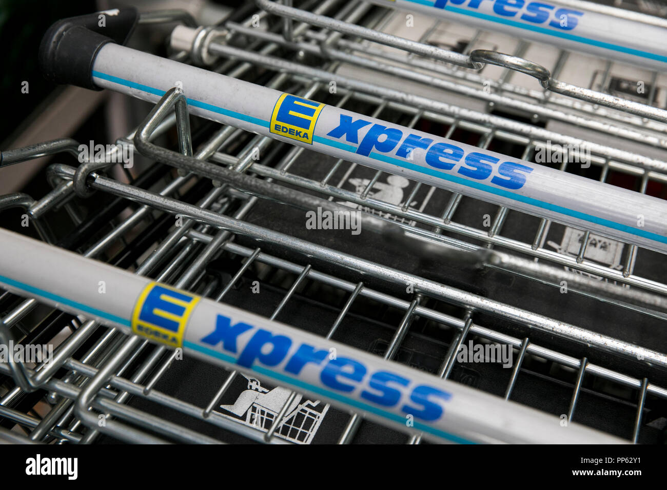 A logo sign outside of an Edeka Express retail grocery store in Munich ...