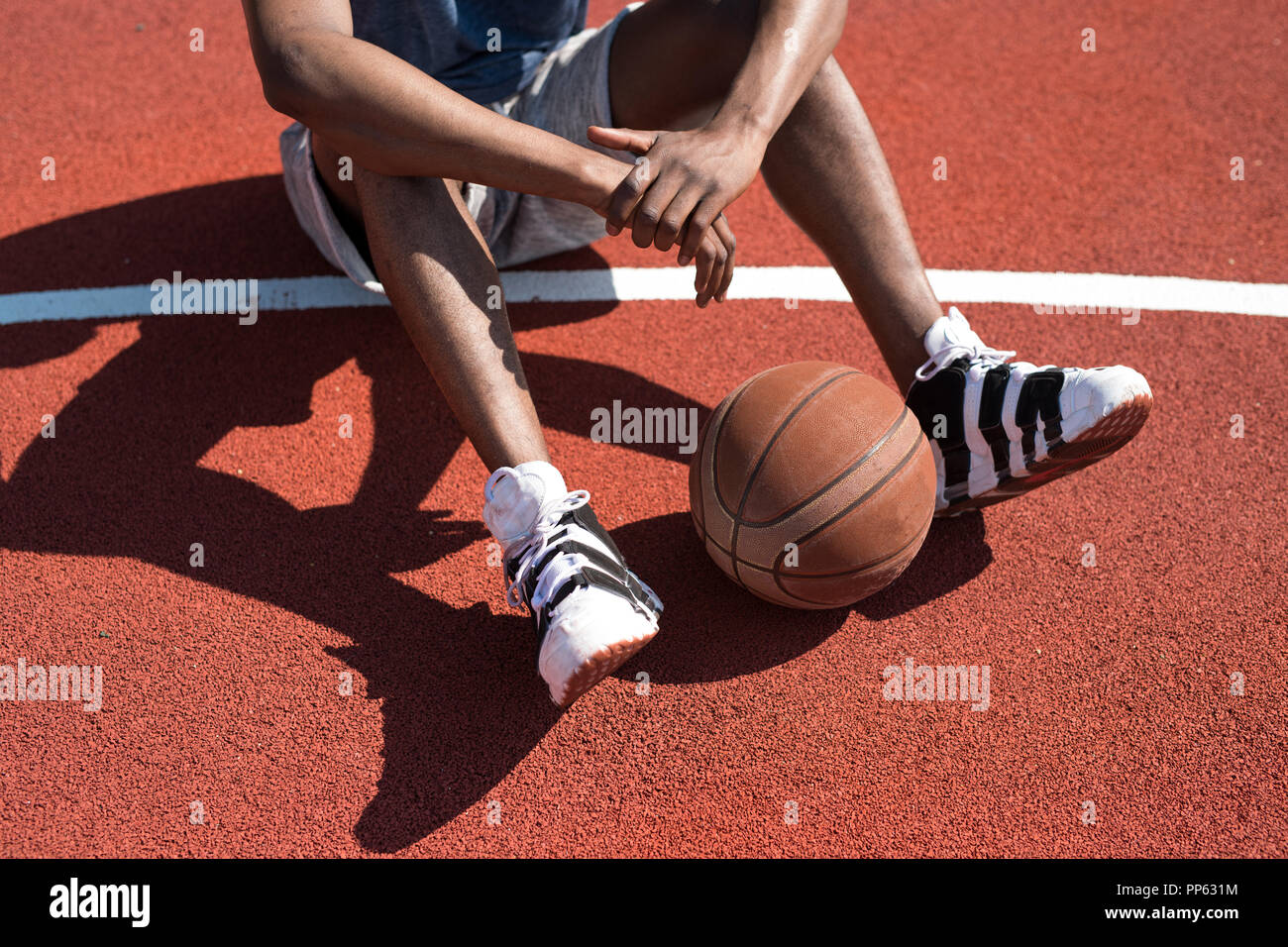 Basketball Player Sitting in Court Stock Photo - Alamy