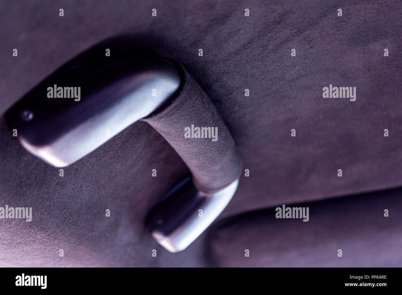 A close-up view of a black plastic handle on the ceiling in a car in a ...