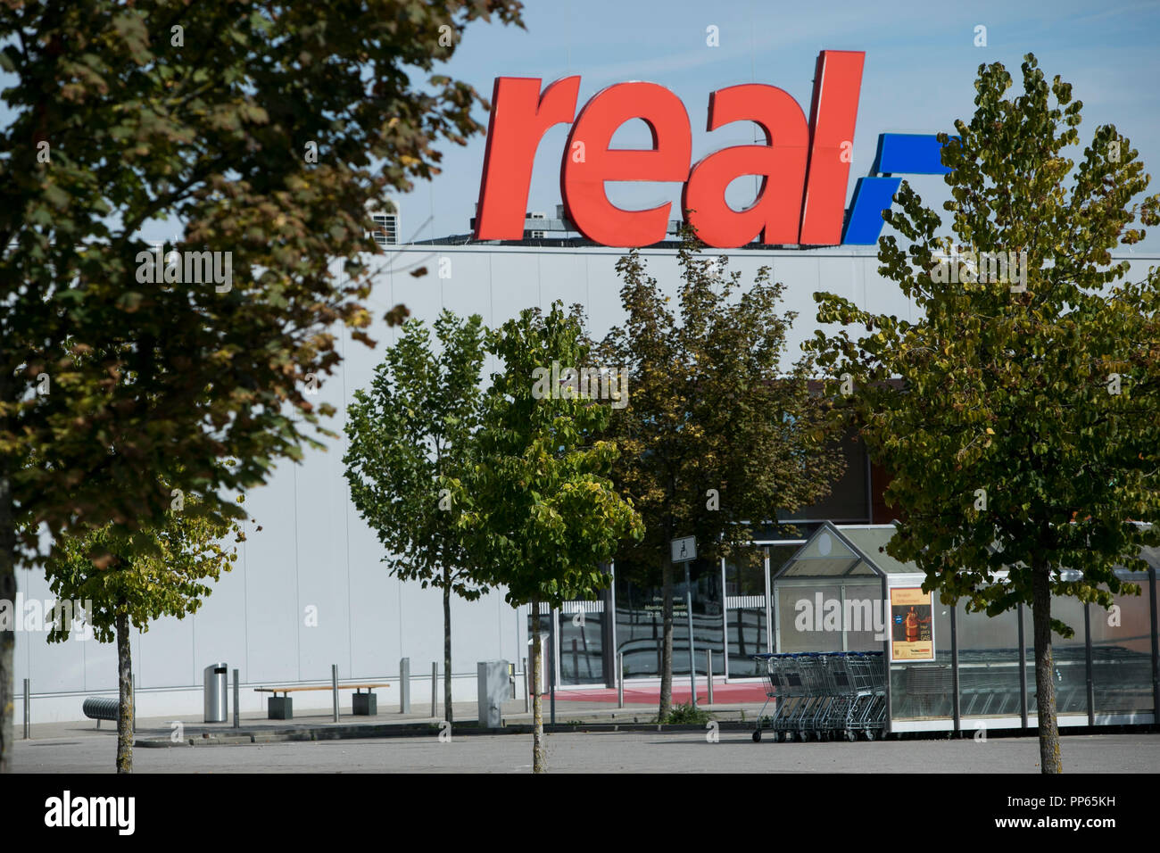A logo sign outside of a Real (real,-) hypermarket retail store in ...