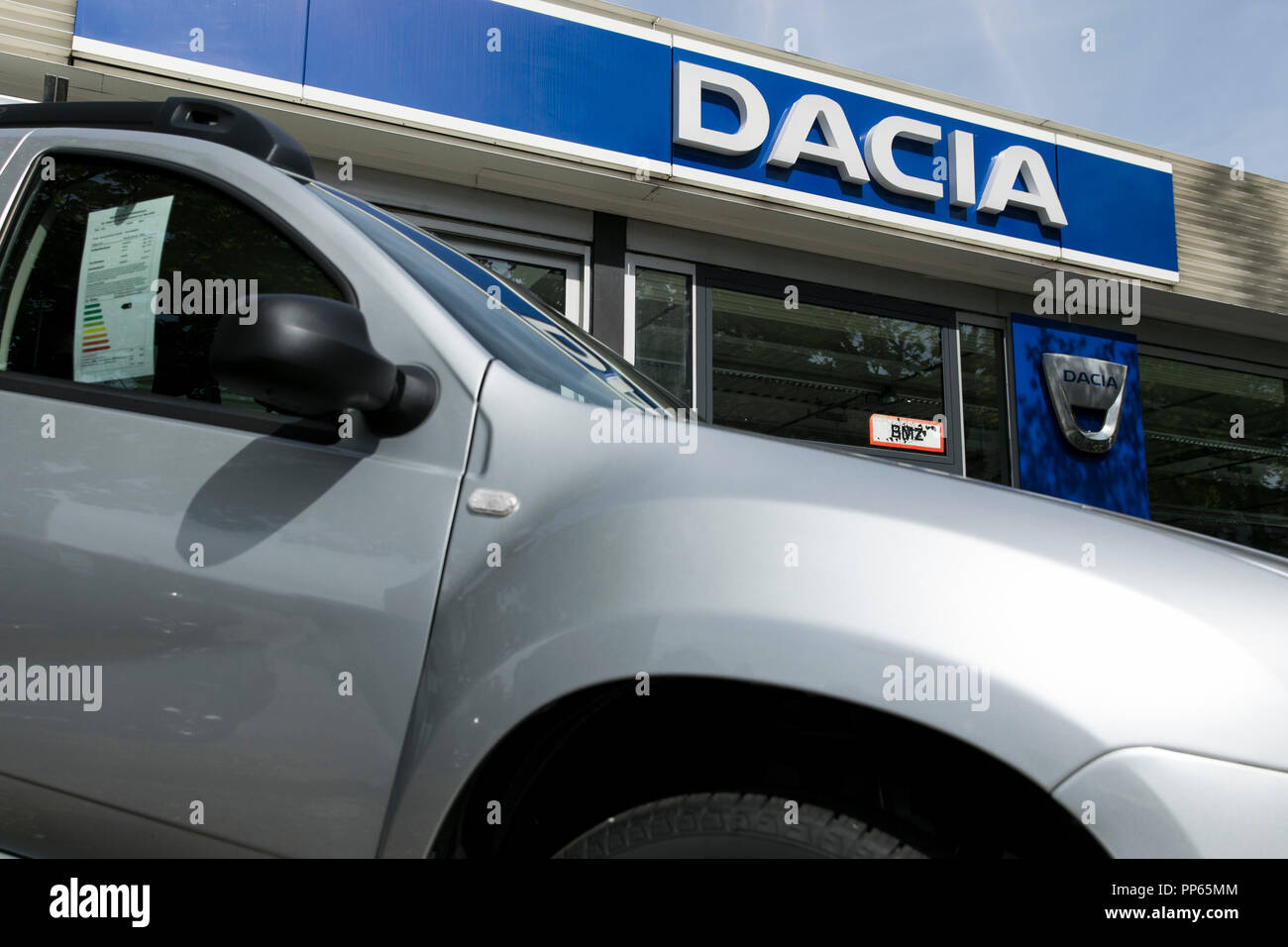 A logo sign and vehicles outside of a Automobile Dacia car dealership ...