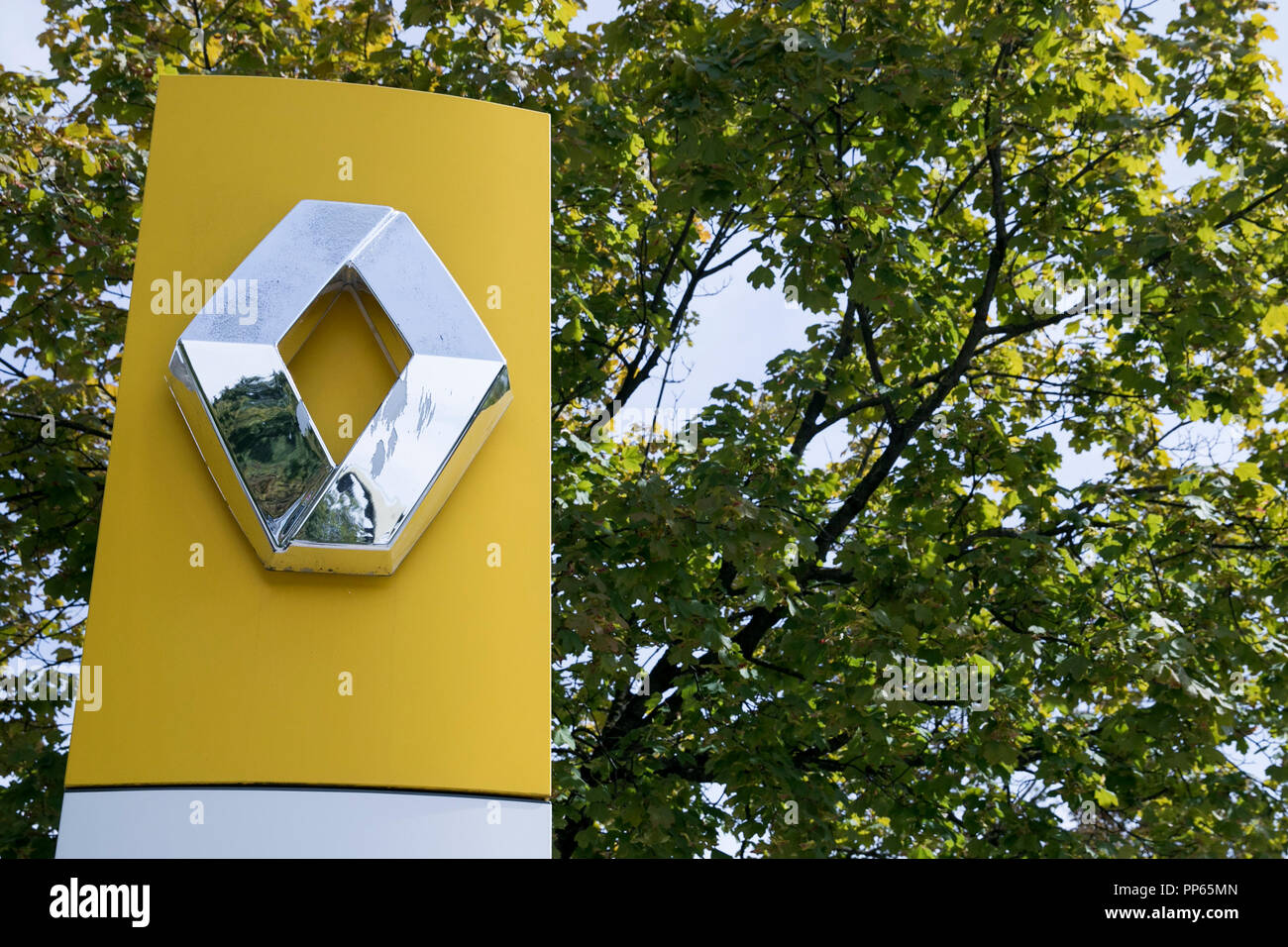 A logo sign and vehicles outside of a Groupe Renault car dealership ...