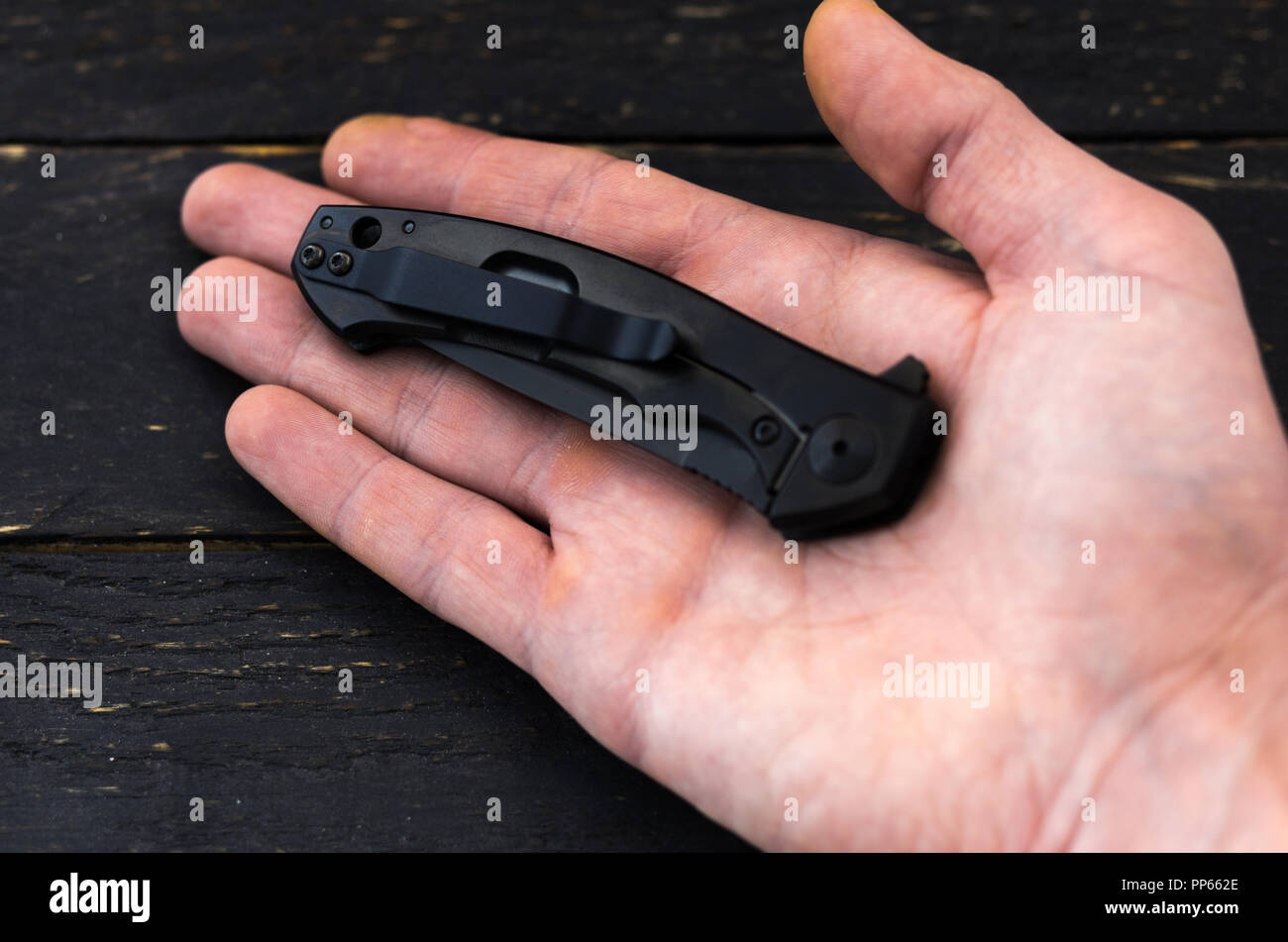 The knife is folded in the palm of your hand. The knife is black Stock ...