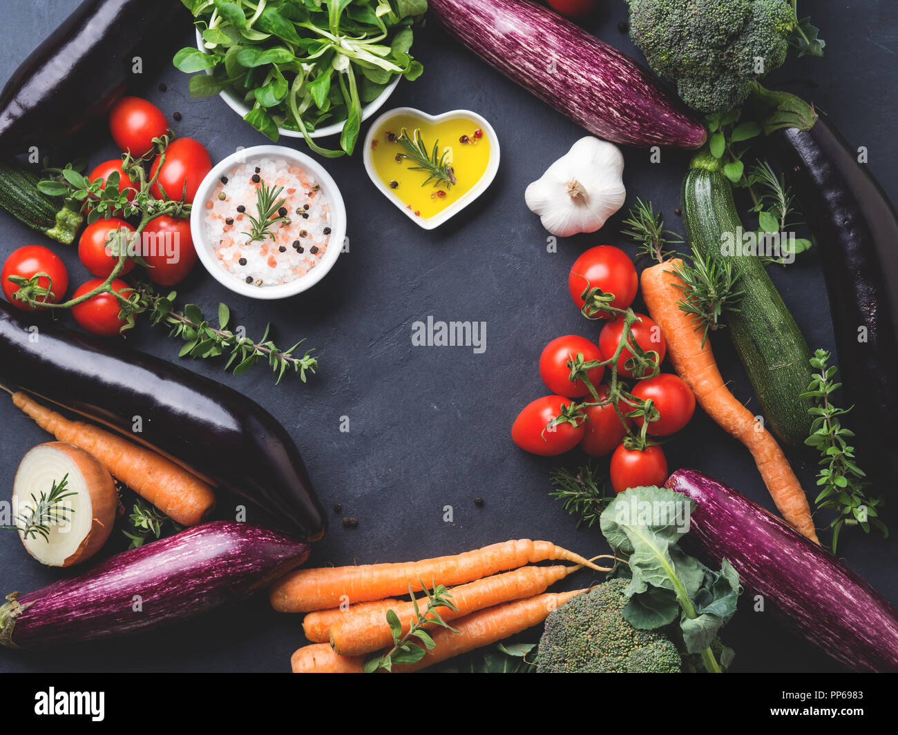 Mix of raw vegetables with salt, spices on dark background. Clean ...