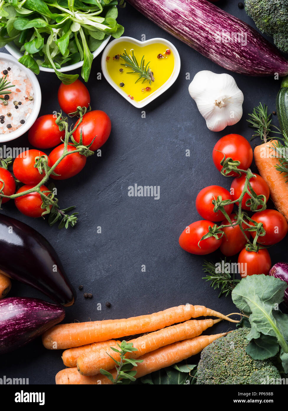 Mix of raw vegetables with salt, spices on dark background. Clean ...