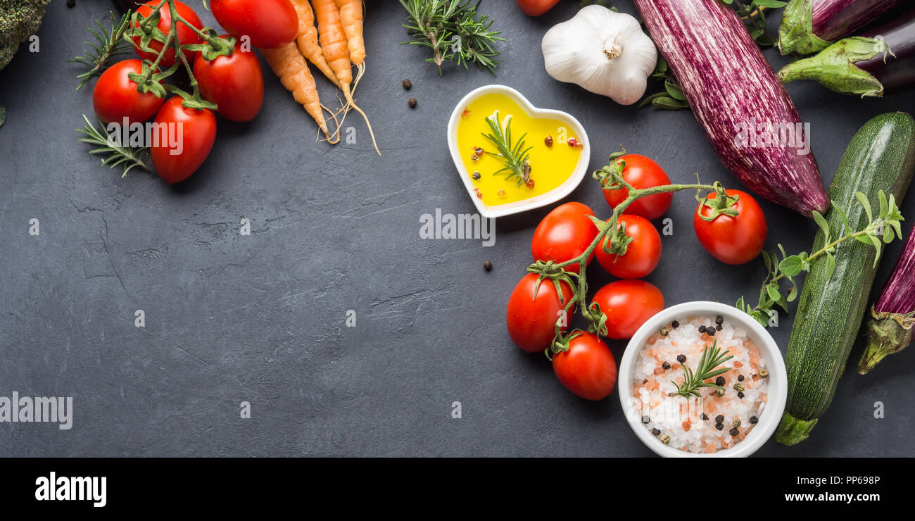 Mix of raw vegetables with salt, spices on dark background. Clean ...