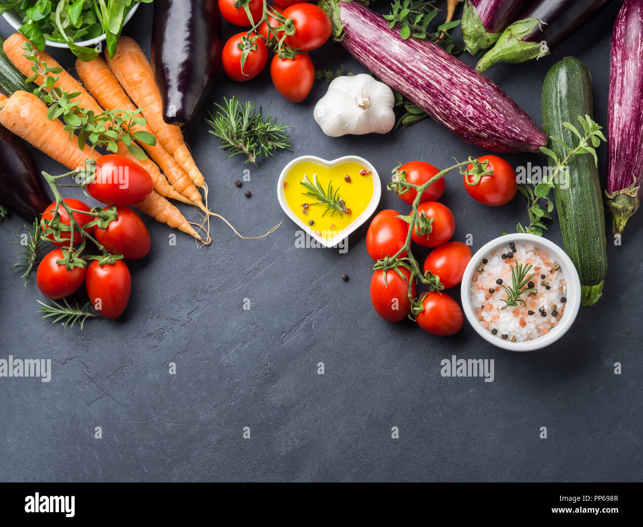 Mix of raw vegetables with salt, spices on dark background. Clean ...