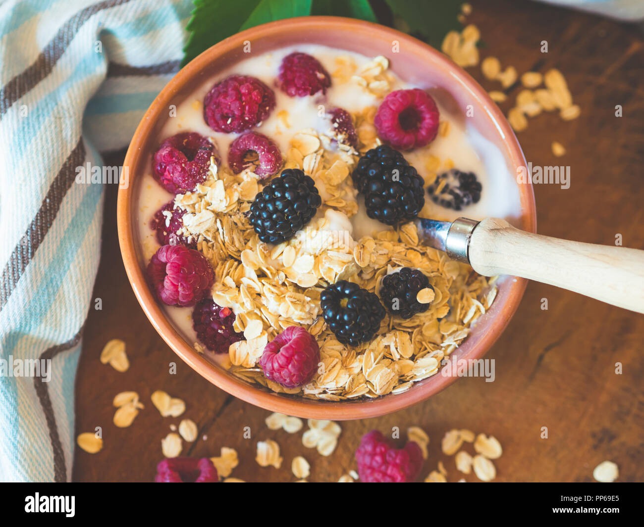 Smoothie yogurt bowl with oats and berries on wooden rustic board. Healthy eating breakfast ...