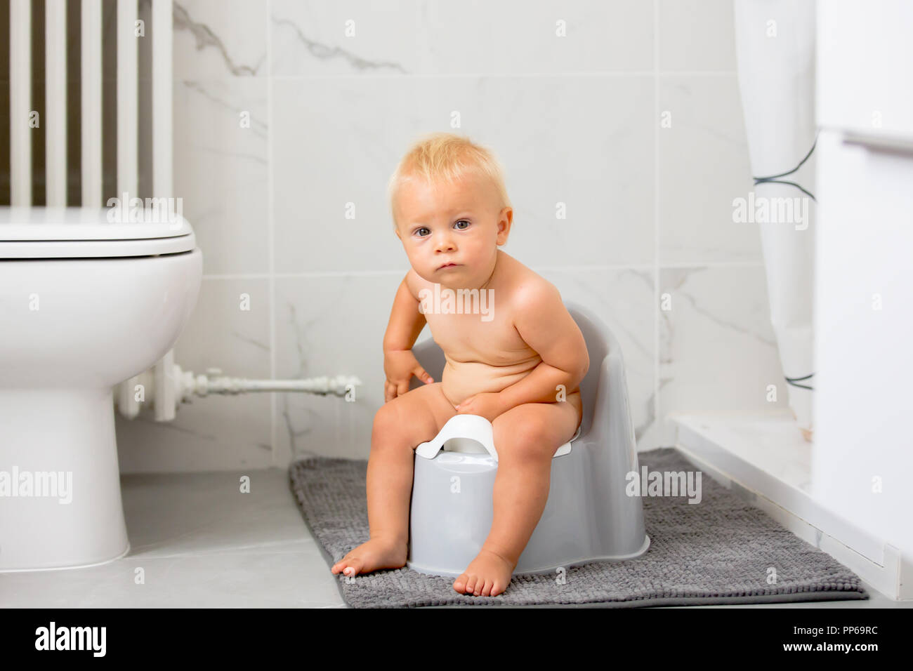 Child sitting on potty. Boy kid playing with educational toy and Toilet ...