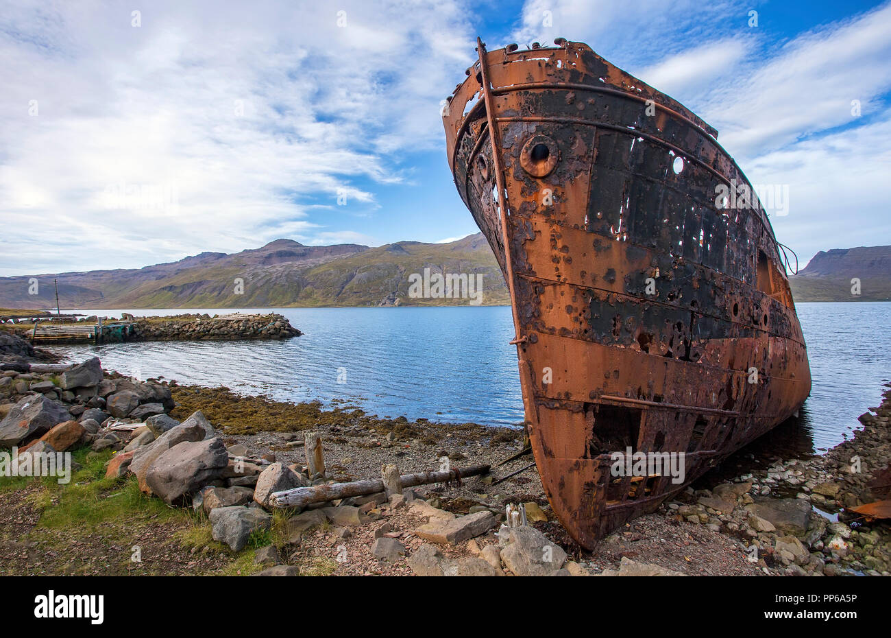 Rusted hull of a steel shipwreck located on the shore of Djúpavík ...