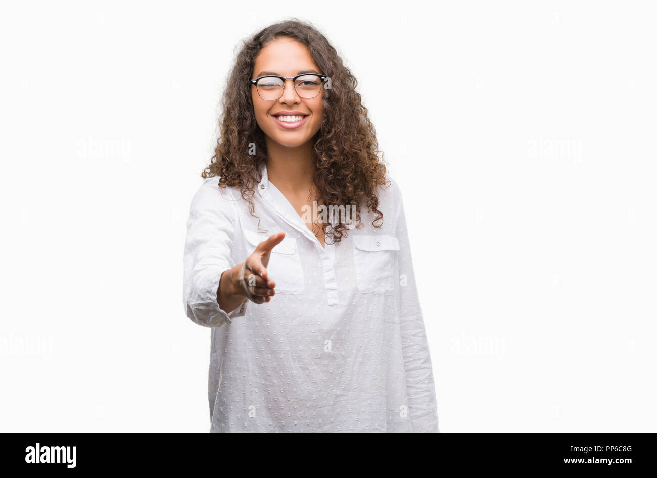 Beautiful young hispanic woman smiling friendly offering handshake as ...
