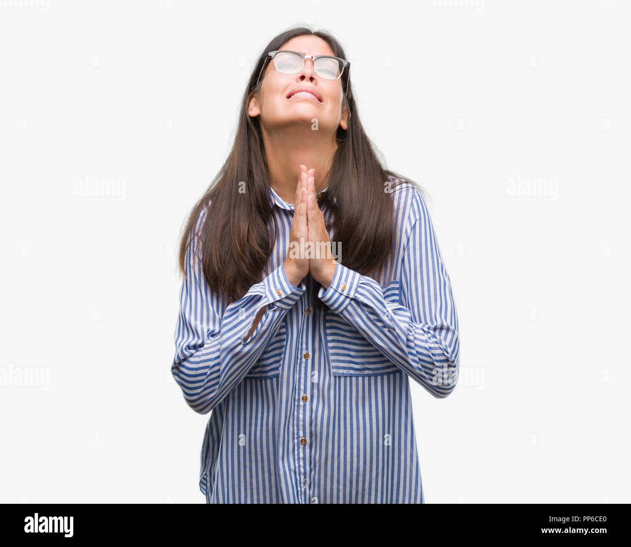Young beautiful hispanic business woman begging and praying with hands ...