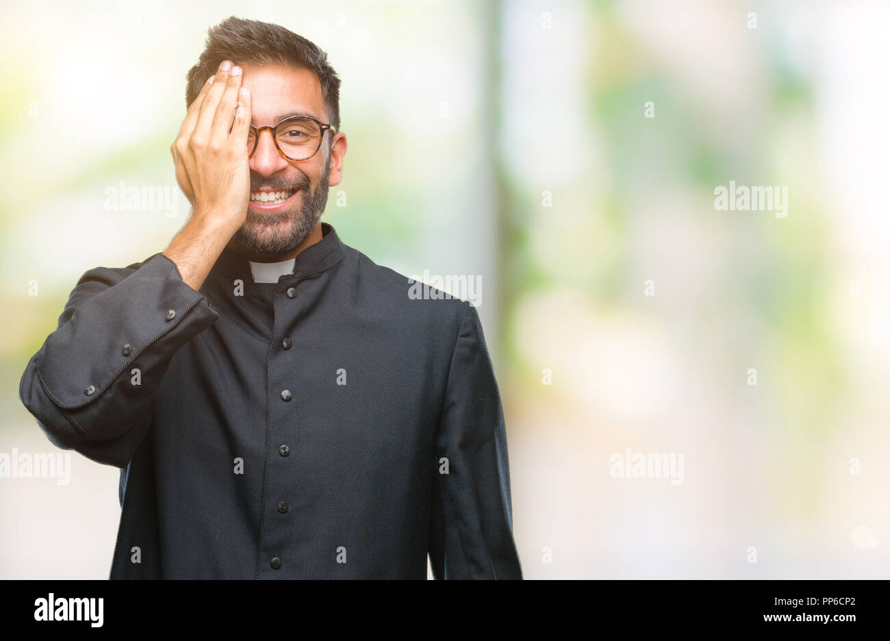 Adult hispanic catholic priest man over isolated background covering ...