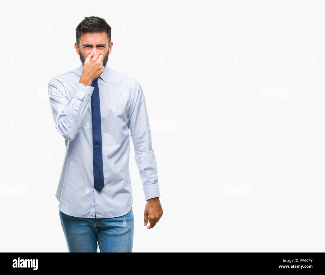 Adult hispanic business man over isolated background smelling something ...